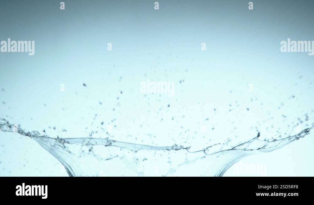 Super slow motion of exploding water splashes on soft blue background ...