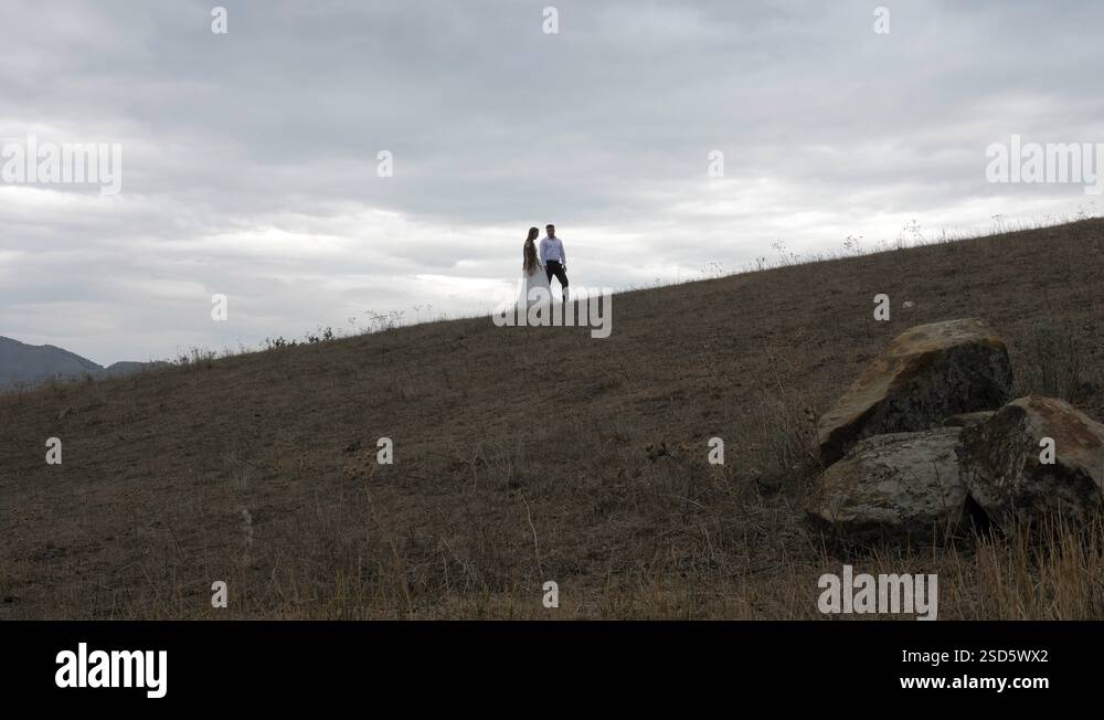 newlyweds silhouettes wander along pictorial hilly landscape Stock ...