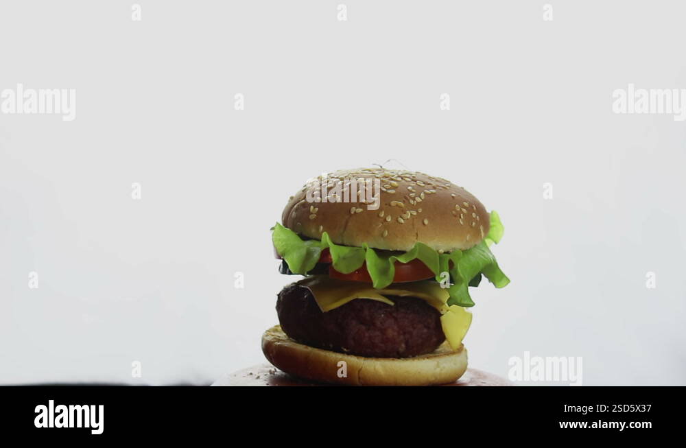 Young handsome guy sniffs and then bites a big juicy burger with great ...