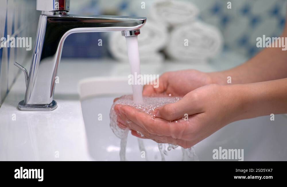 Water tap with running water and teenage hands. Washing hands under ...