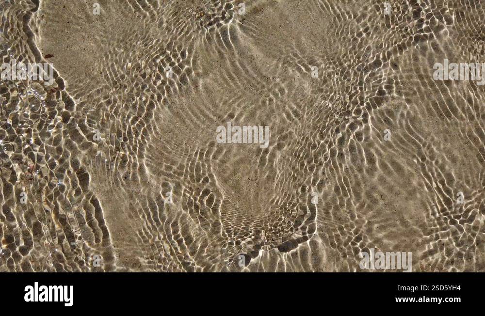 Sandy shallow water, beach. Weak ripples on the surface of the water as ...