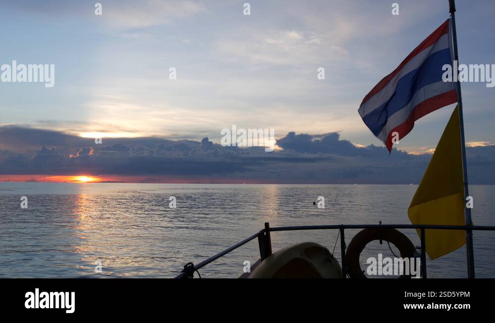 Boat floating with flags in evening. Thai and King of Thailand flags ...