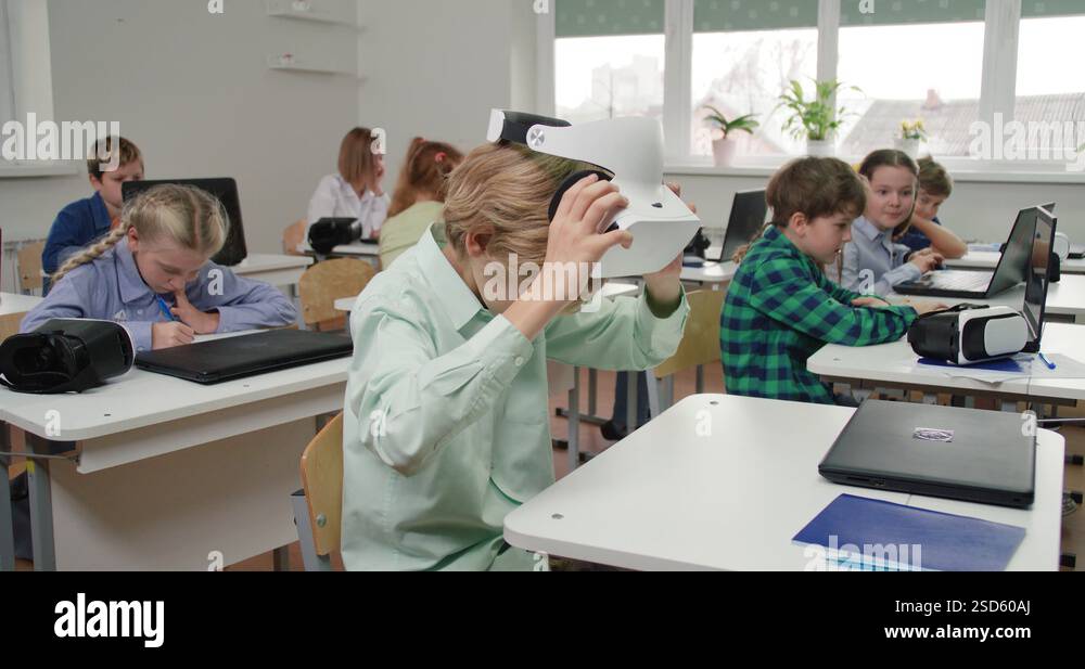 Education at modern school, boy in virtual reality glasses, interacts ...