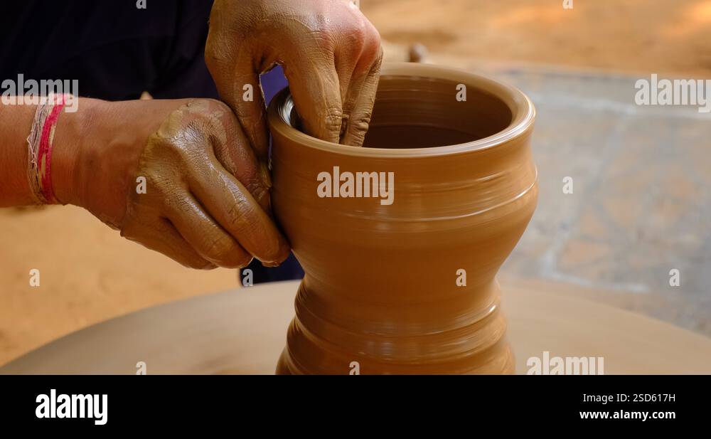 Skilled hands of potter shaping the clay on potter wheel and sculpting ...