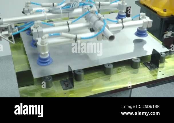 Automated robotic arm system with suction cups and pneumatic tubing used for industrial material ...