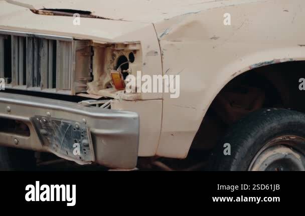 Close-up of a damaged and rusty old car in the desert. The car appears ...