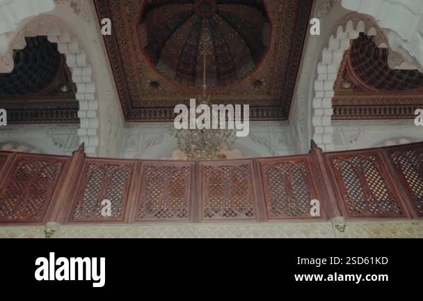 Ornate wooden lattice and intricate ceiling with chandelier in mosque ...