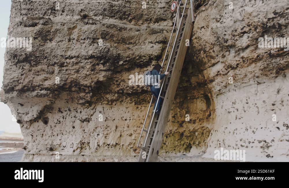 Happy excited tourist woman climbing down ladder on epic white rock at ...
