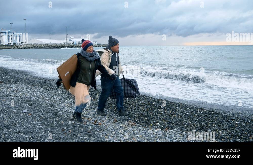 happy homeless couple, a man and a woman running on the beach Stock ...