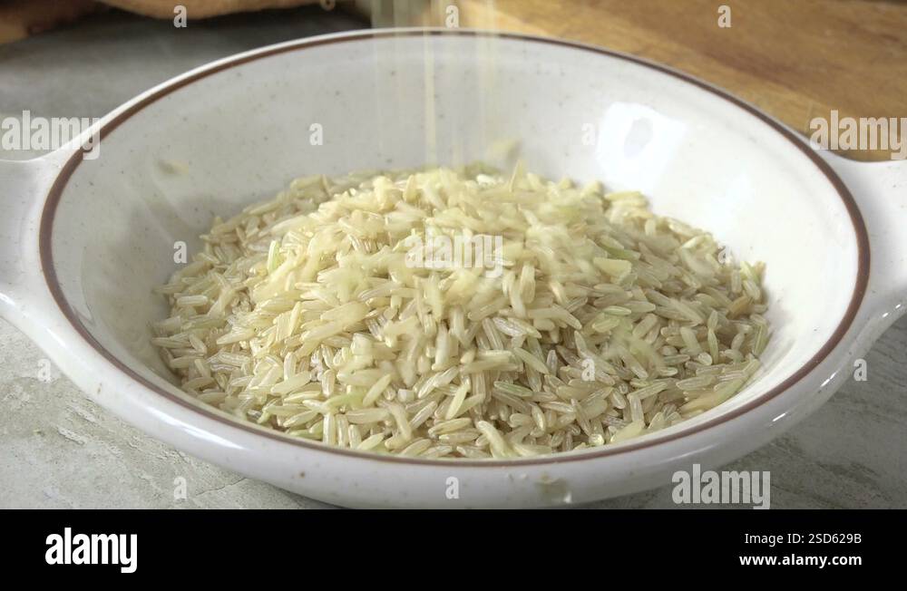 Pouring rice into a small bowl Stock Video Footage - Alamy
