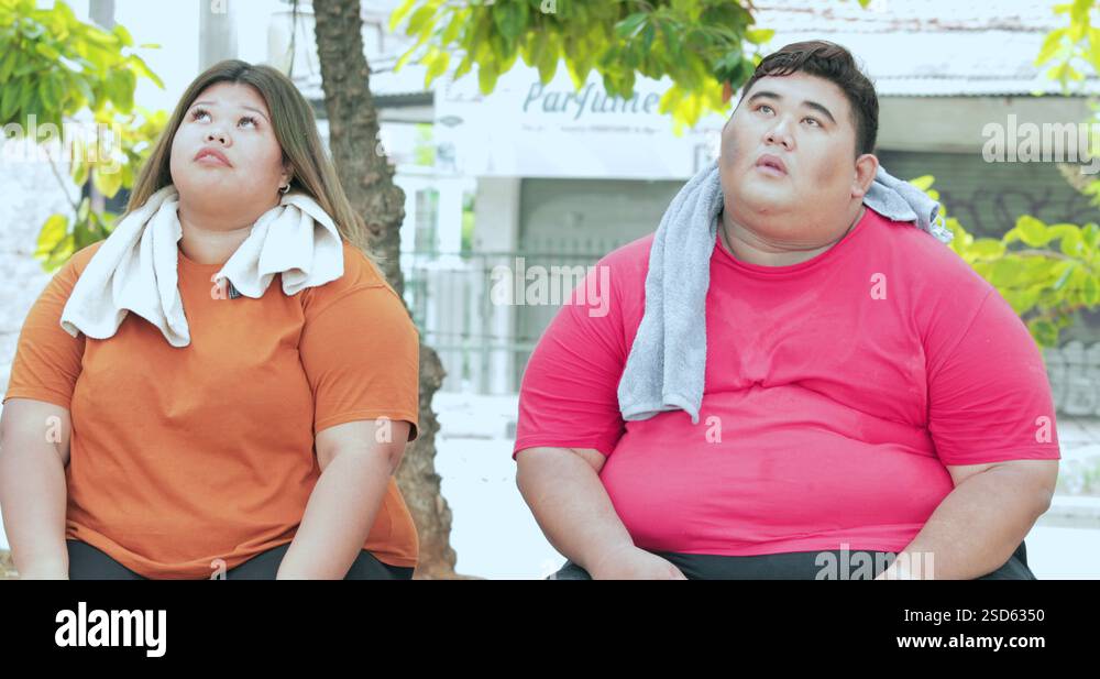 Obese couple sitting and relaxing at park Stock Video Footage - Alamy
