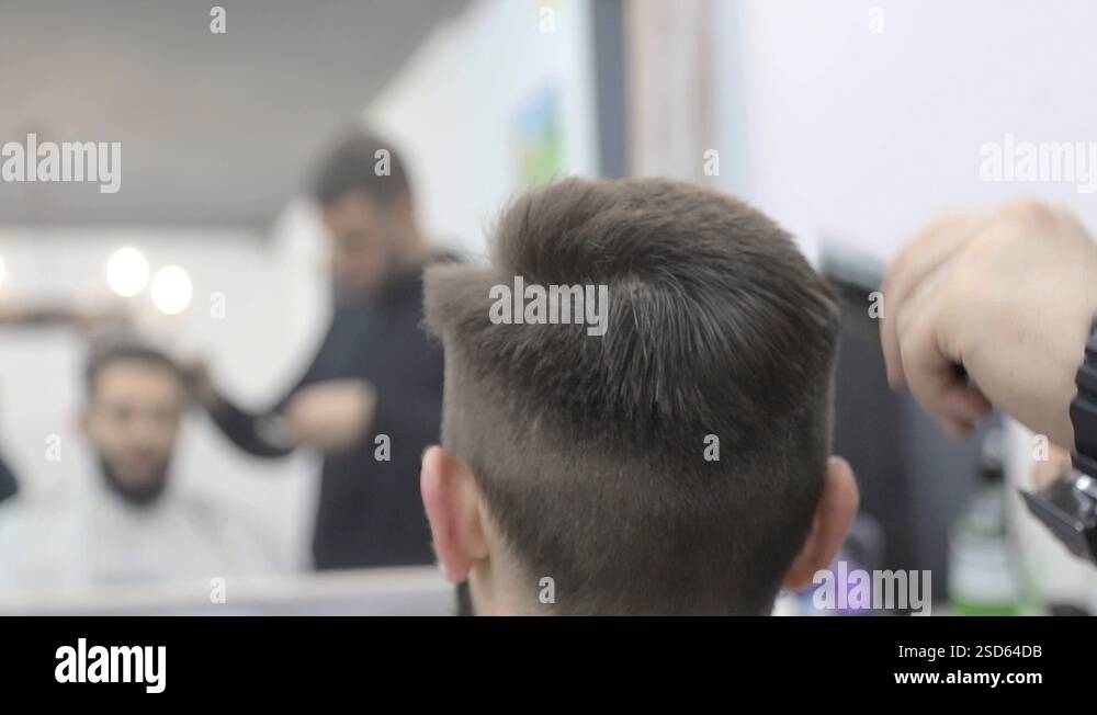 Haircut in a Barbershop. Barber cuts her husband's hair with a clipper ...