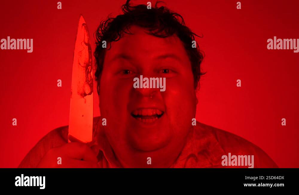 Angry horrible man covered with blood. Red lighting for more disturbing ...