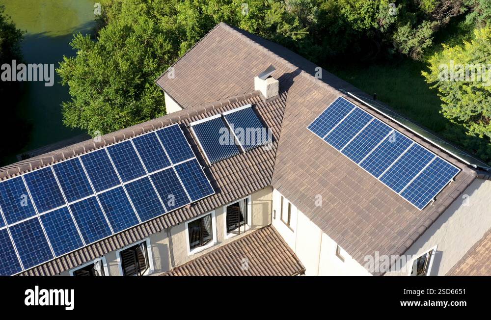 Close-up aerial zoom out view of solar panels on a suburban house roof ...