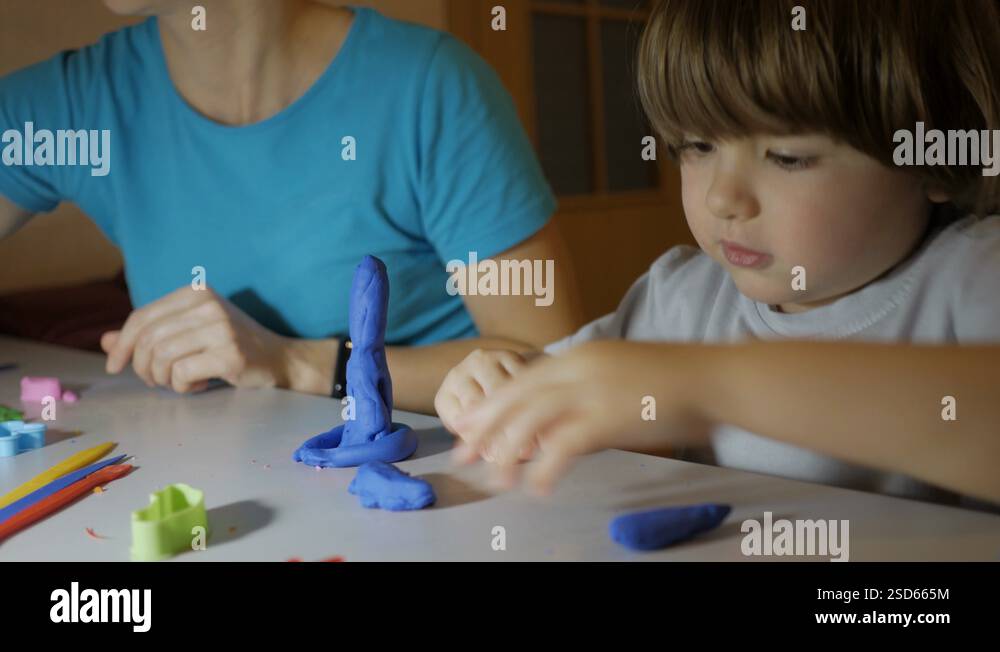 Child in Process of Modeling of Plasticine at Table in Nursery Room ...