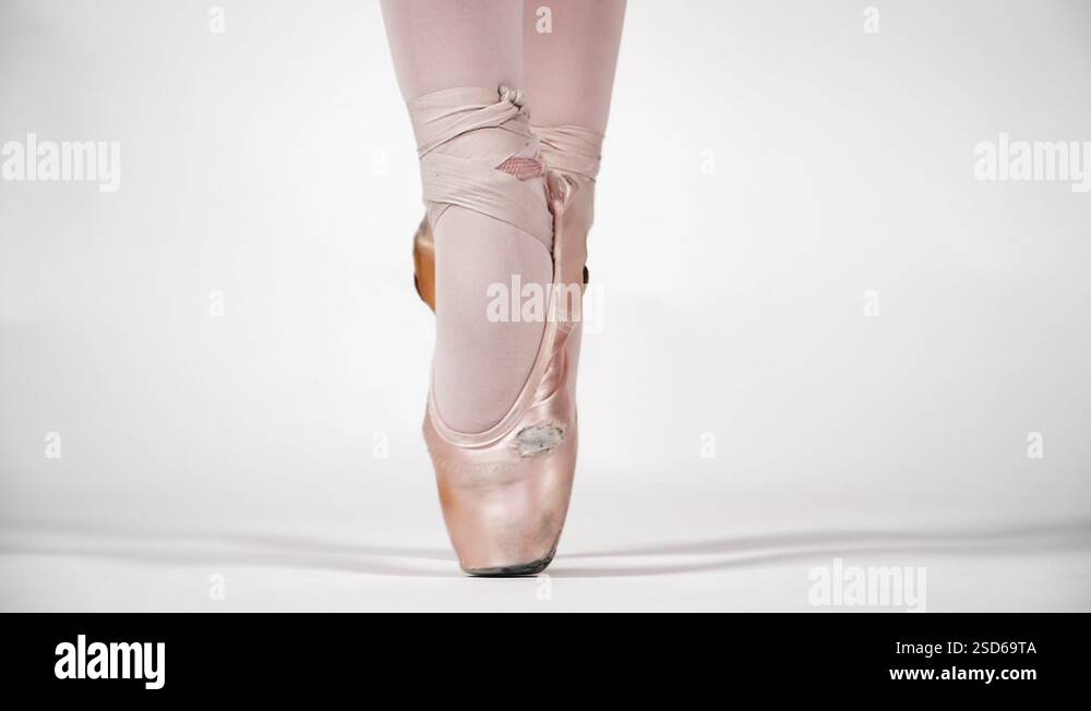Beautiful legs of a ballerina in Pointe on a white background, closeup ...