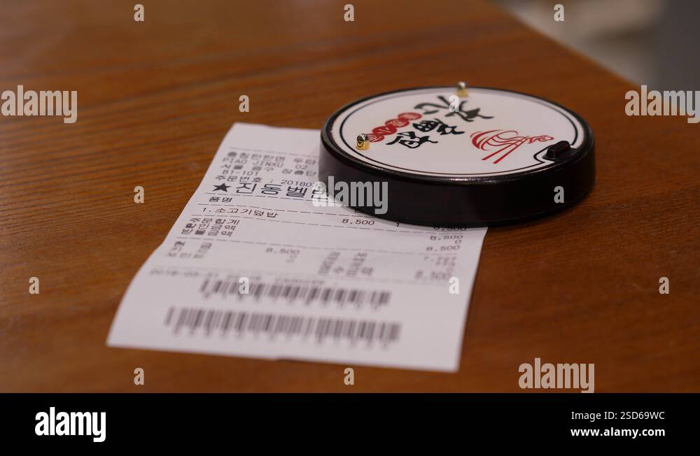 Round pager lie on paper slip, alarm device at Korean restaurant Stock ...