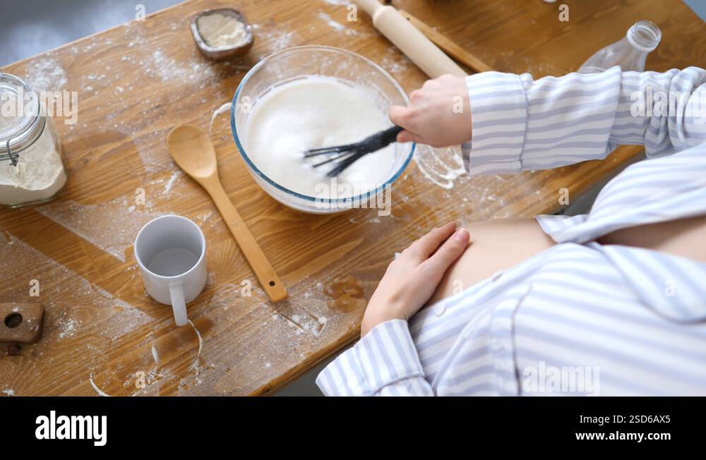 Pregnant Woman Beating Up Milk In A Bowl While Cooking Breakfast In ...