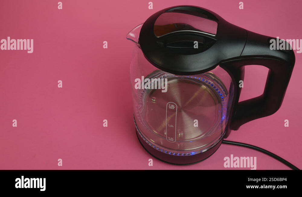 Boiling water in a glass teapot on a pink background.view from above ...