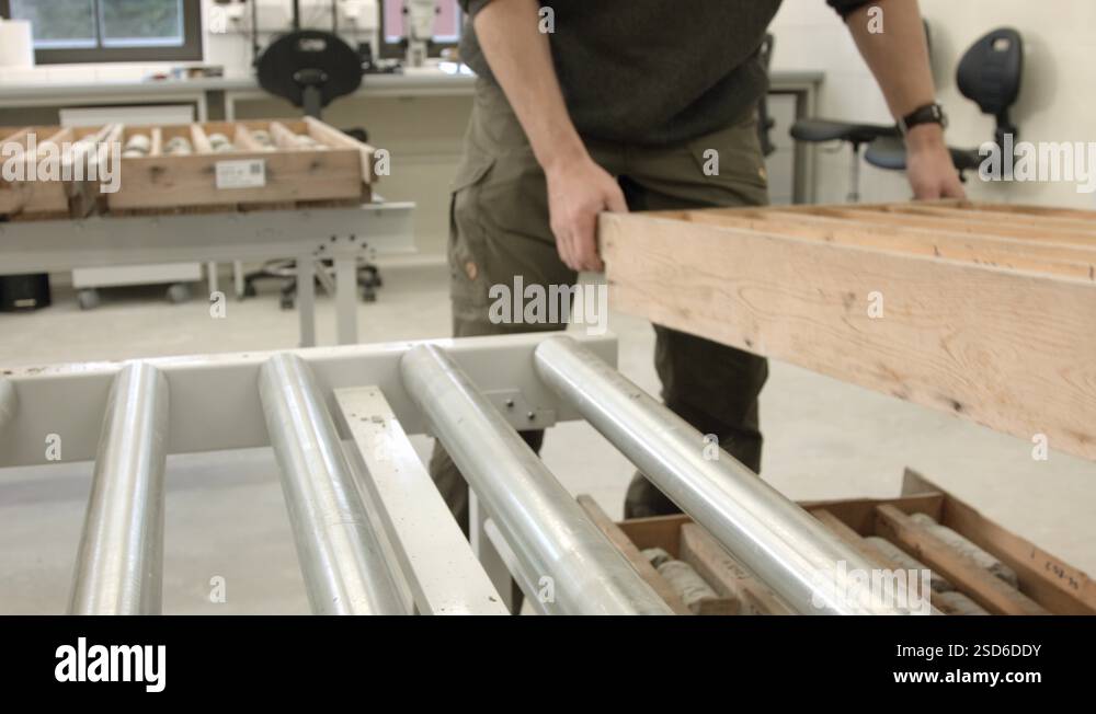 Geologists lifting drilled rock core sample boxes for laboratory ...