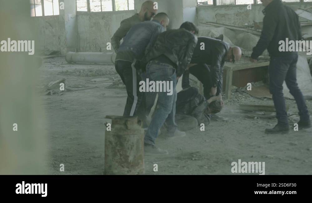 Footage of criminal scene. Group of men fighting in abandoned building ...