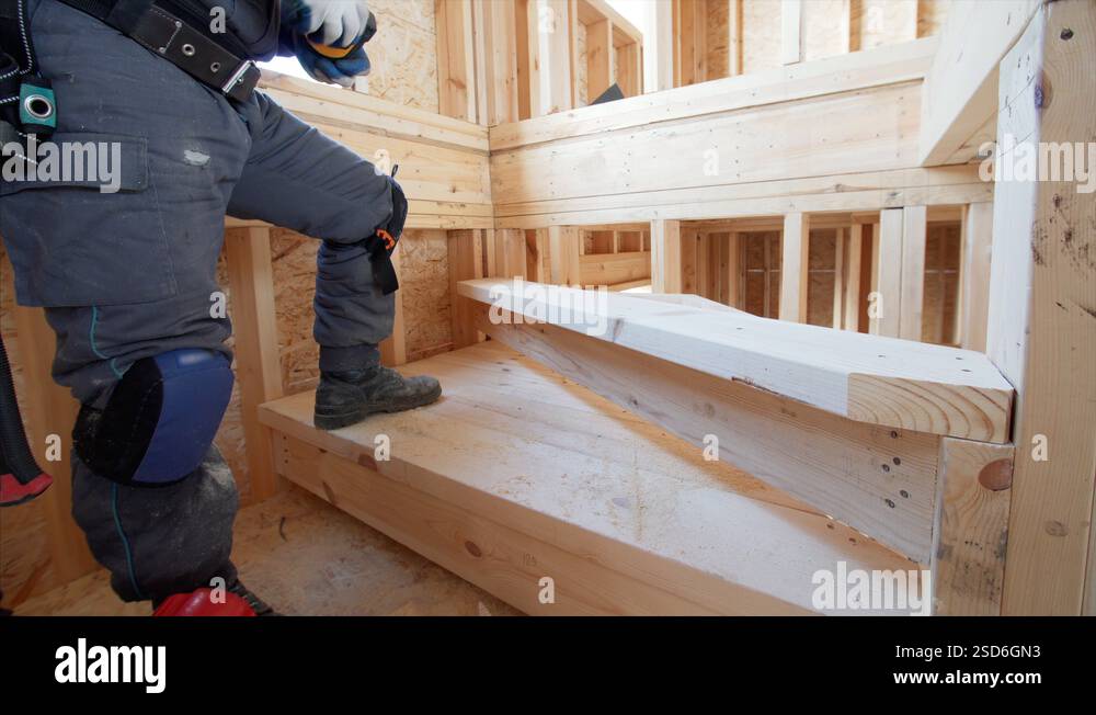 Builder measures board with measuring tap while building ladder. Frame ...