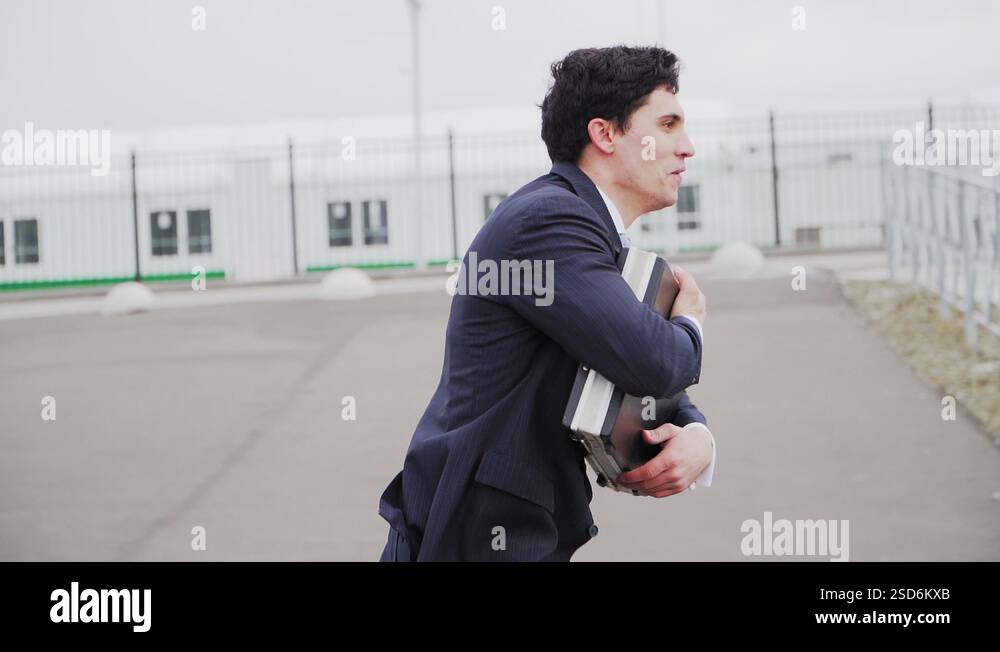 Caucasian Guy in a business suit runs off with the briefcase in hand ...