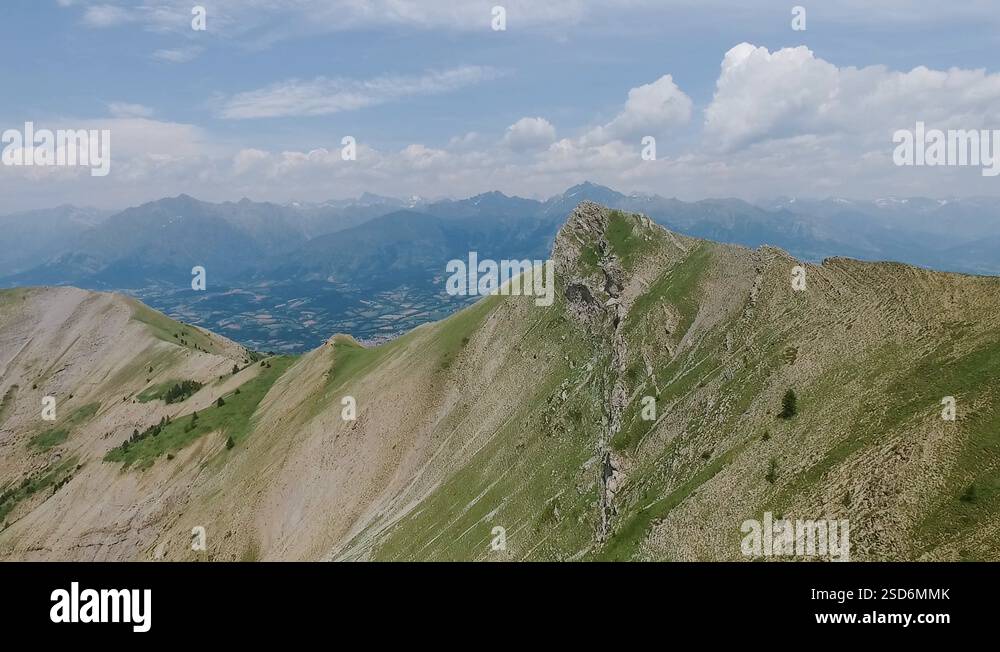 Flying over the top of mountain, aerial alpine view with sharp peak in ...