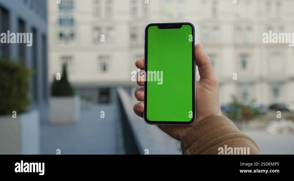 Vertical black phone with chroma key on the screen is in the female ...