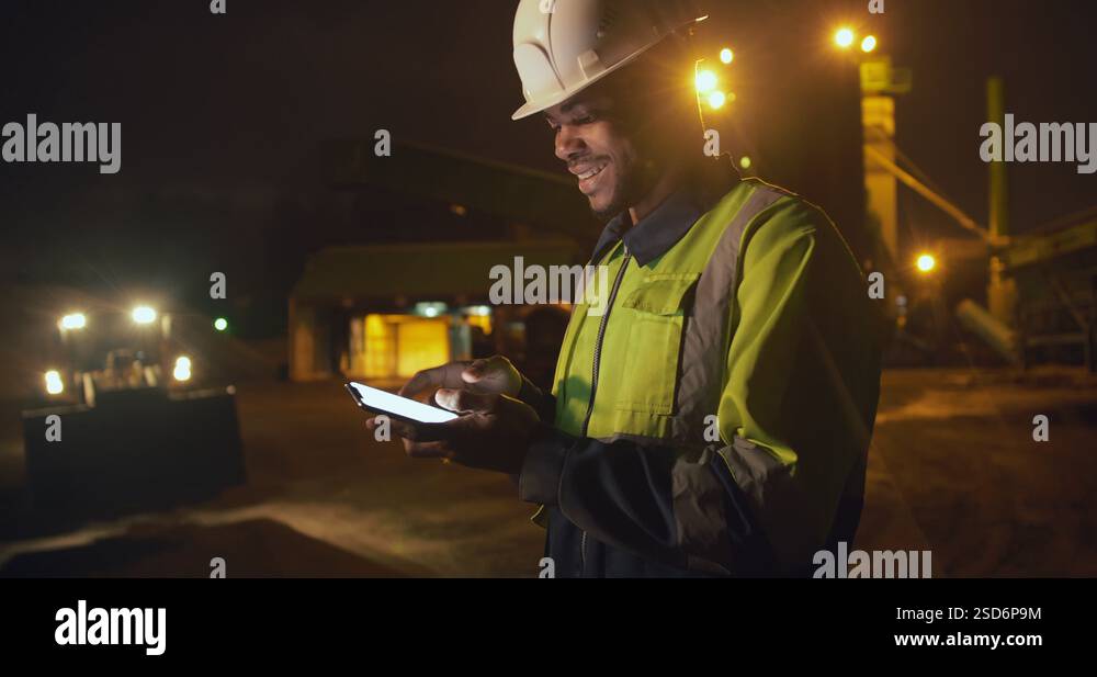 Engineer using smartphone while working night shift on road ...