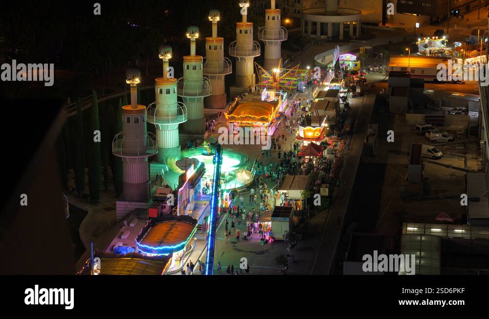 Many attractions at fair-ground, people flow at night, time lapse shot ...