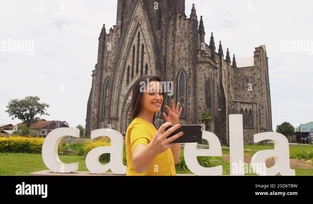 tourist Woman in front of church in Canela Brazil taking mobile phone ...