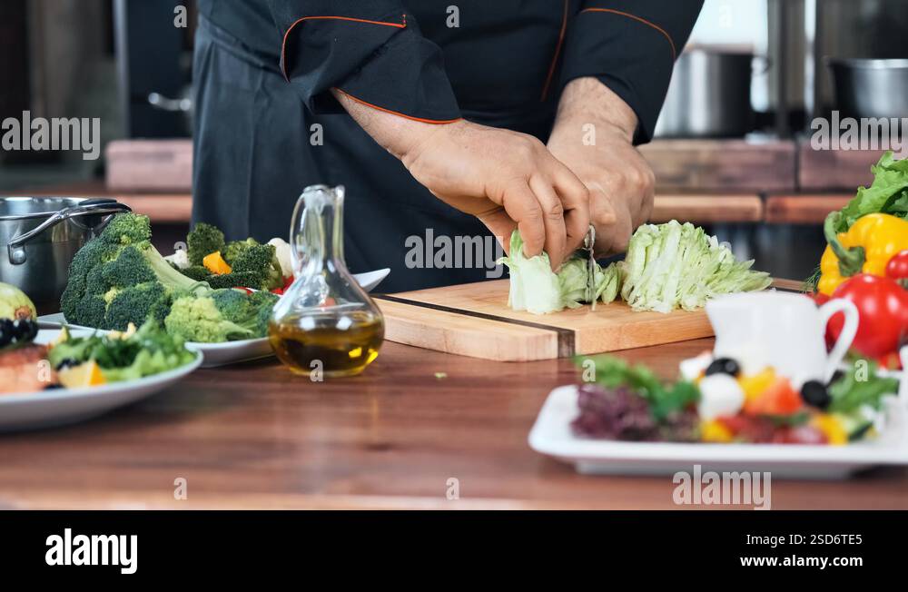 Chief cook arm cutting raw lettuce leaf. Medium close up shot on 4k RED ...