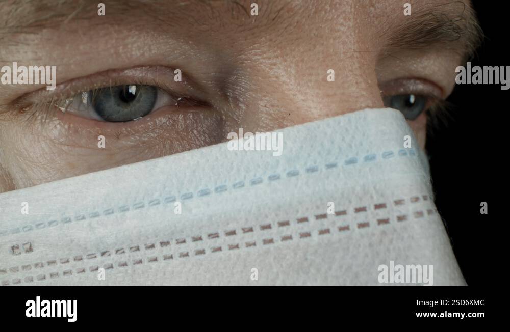 Close-up of human face, european man wearing protective medical mask ...