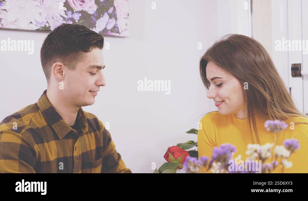 Adorable couple is communication and sitting in cafe. Boy presents his ...