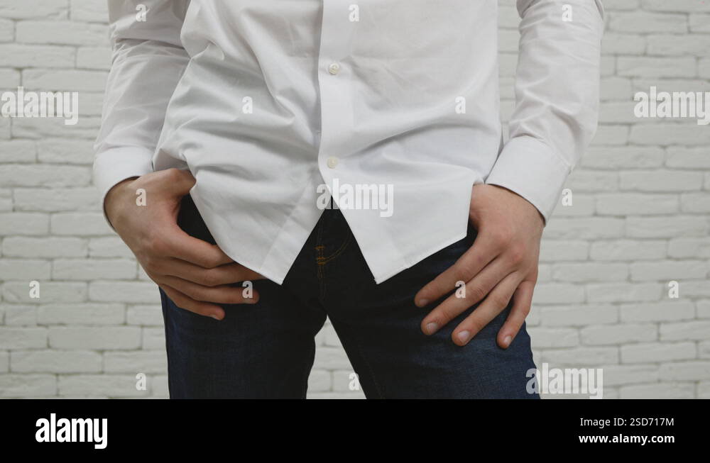 man without face in a white shirt holding his hands in pockets folds ...