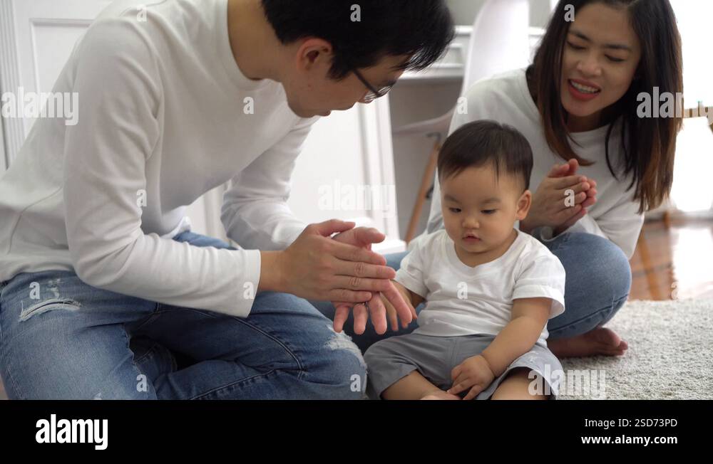 Happy Asian family of three, young father and mother playing games and ...