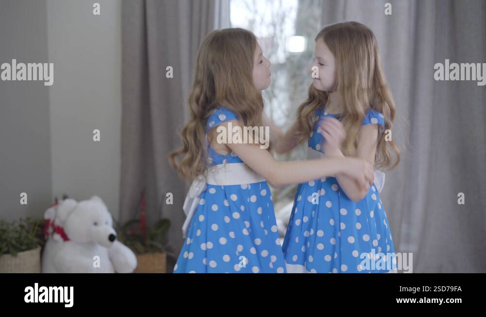 Side view of two identical sisters having fun at home. Joyful Caucasian twins in Stock Video ...