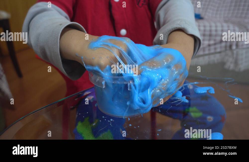 Hands of a kid stuck in slime toy Stock Video Footage - Alamy