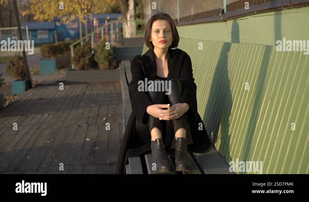 Playful woman relaxing on street bench and nodding her head Stock Video ...