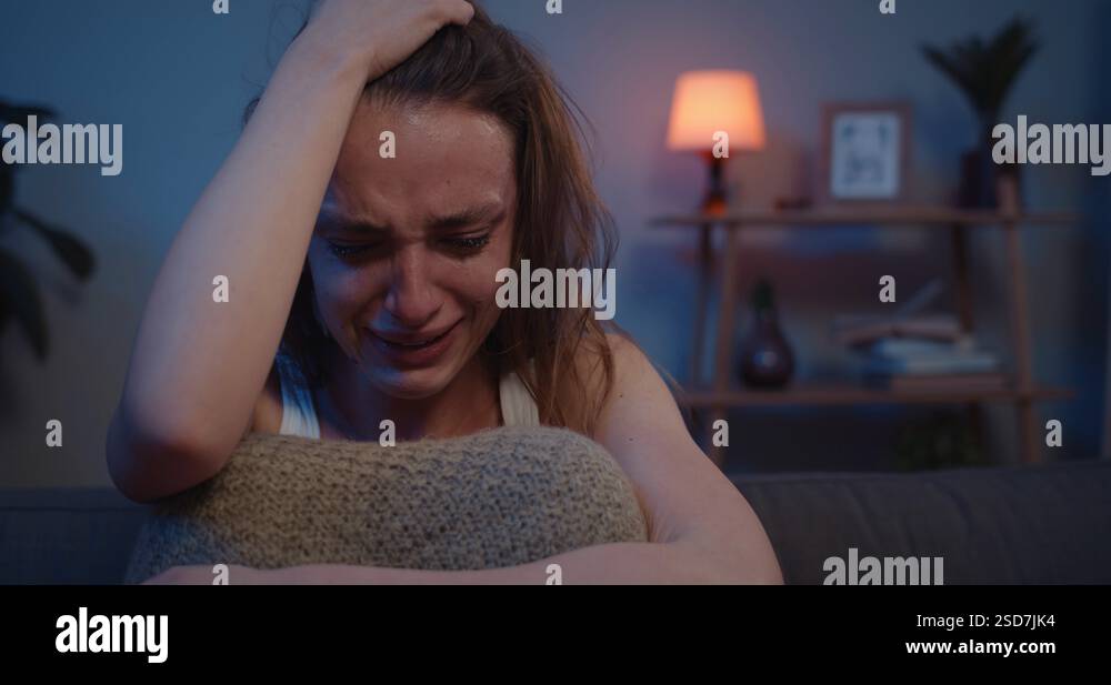 Close up of unhappy woman sitting in fetal position and weeping ...