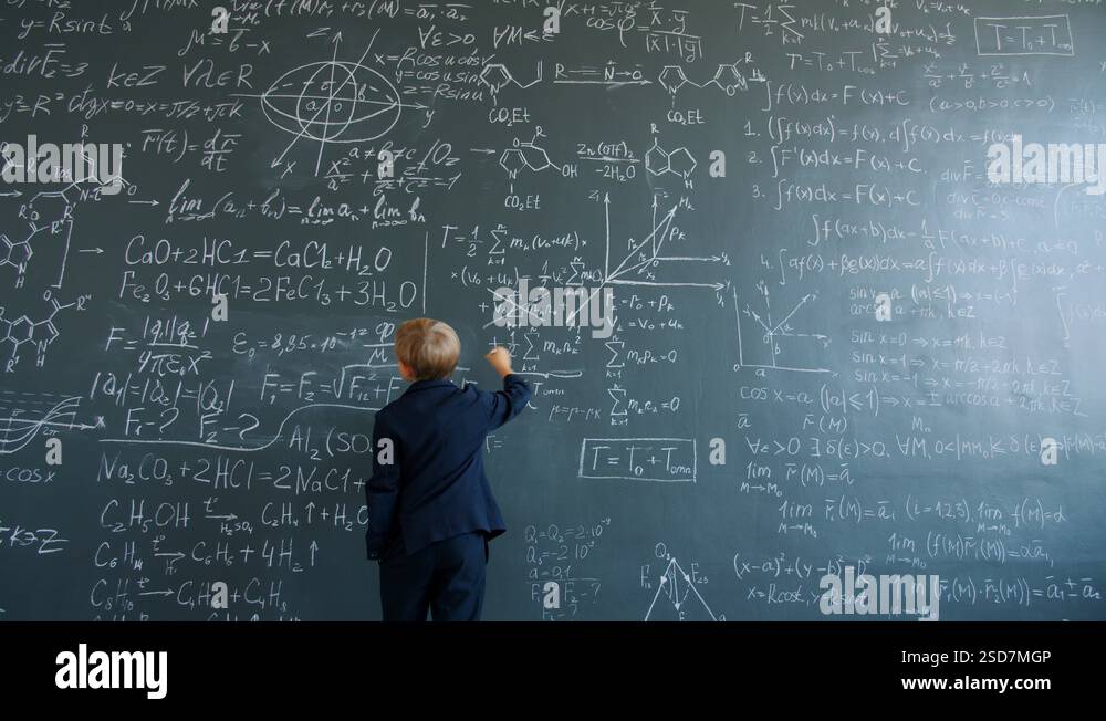 Slow motion of intelligent child writing formulas on blackboard wall in ...