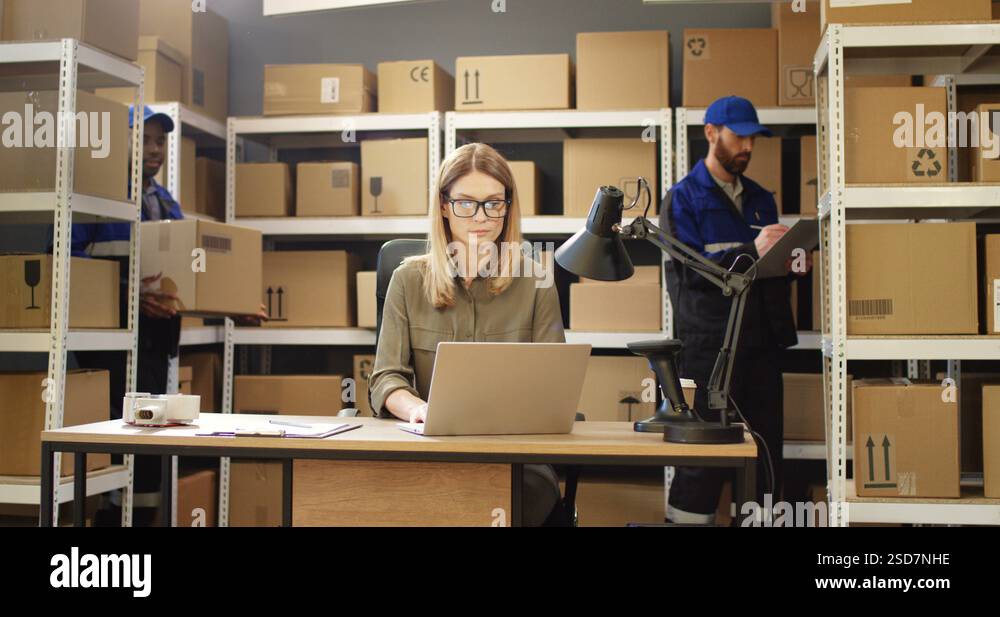 Caucasian woman post worker sitting at table and working at computer in ...