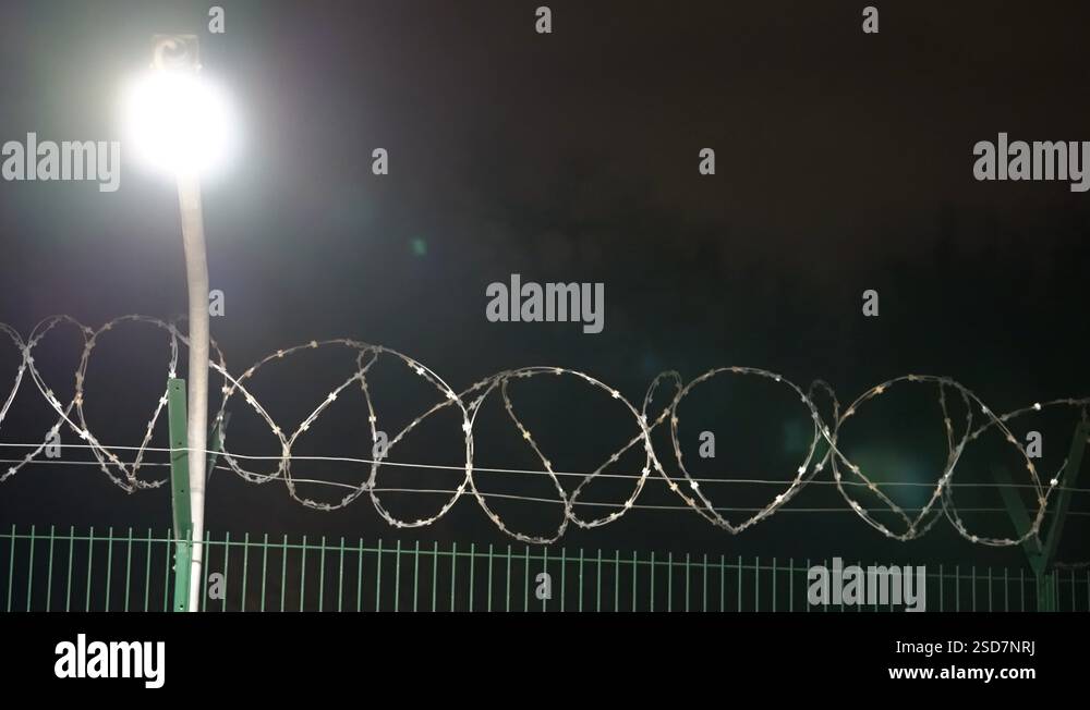 Perimeter security fencing system. Razor wire on top of perimeter fence ...