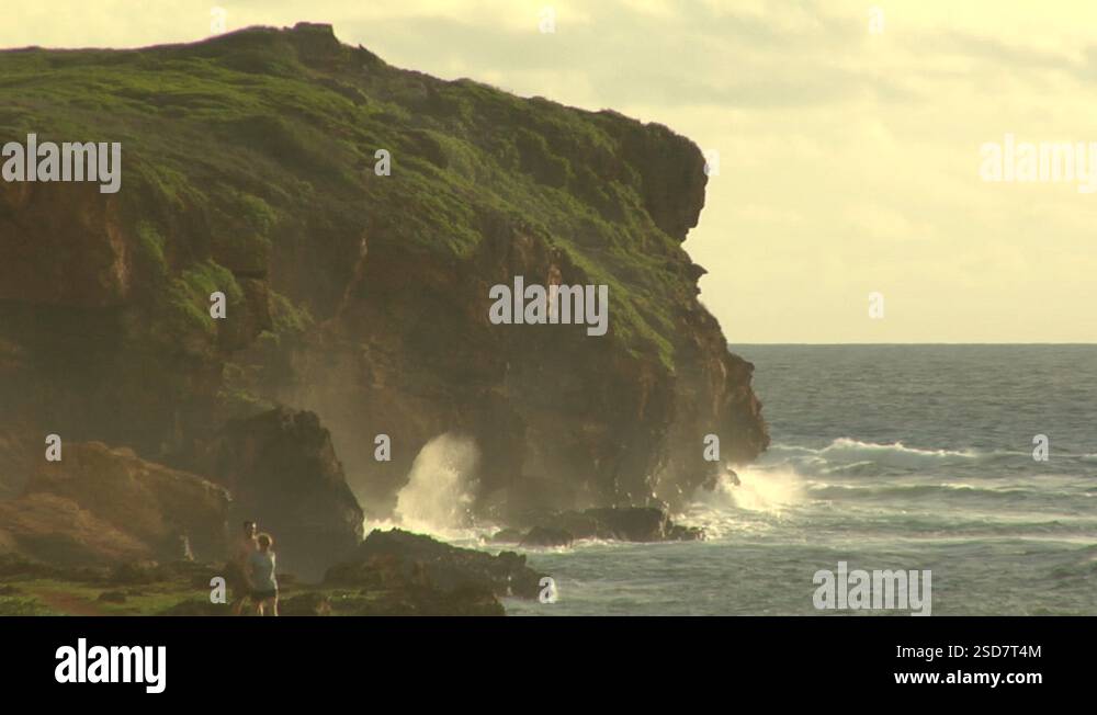 Ocean waves crash onto cliff behind golf course putting green B Stock ...