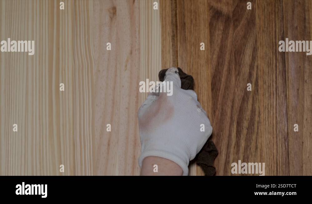 Wood working staining wooden door with rag by hand. Applying dark color ...