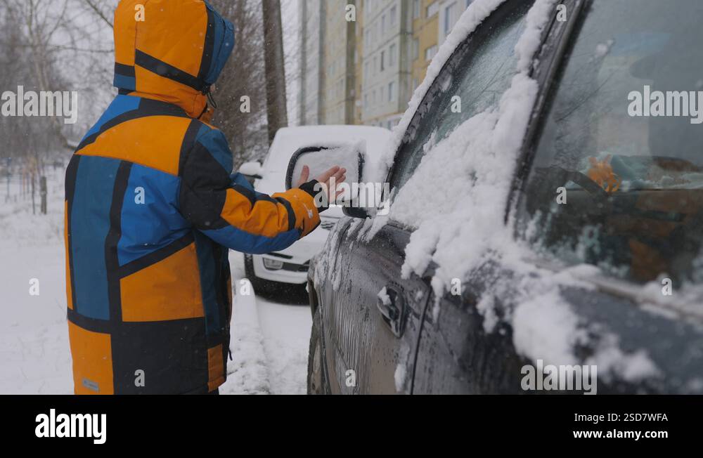 Cleaning the side window of the car from snow. Cleaning the rearview ...