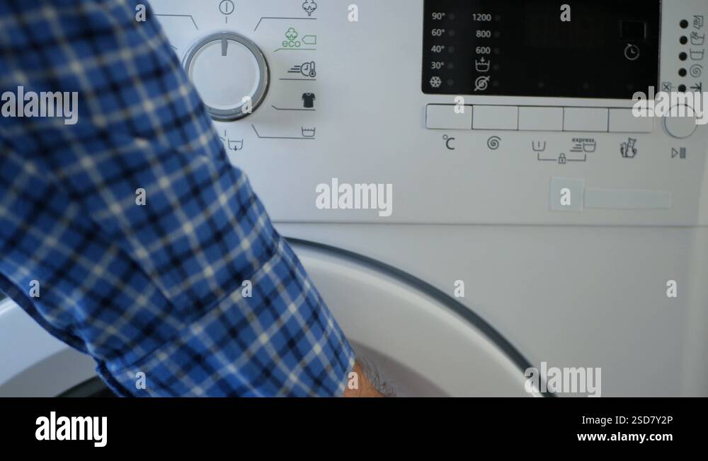 Man Put Dirty Clothes in Laundry Machine Set the Program and Push Power ...