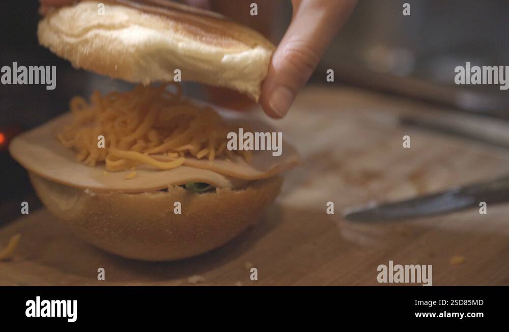 A person making a sandwich with ham and chess on the bread - Close Up ...