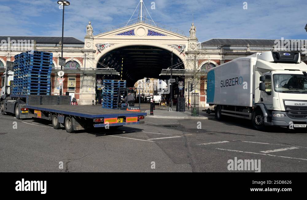 Forklift truck loading wooden pallets onto the back of a lorry trailer ...